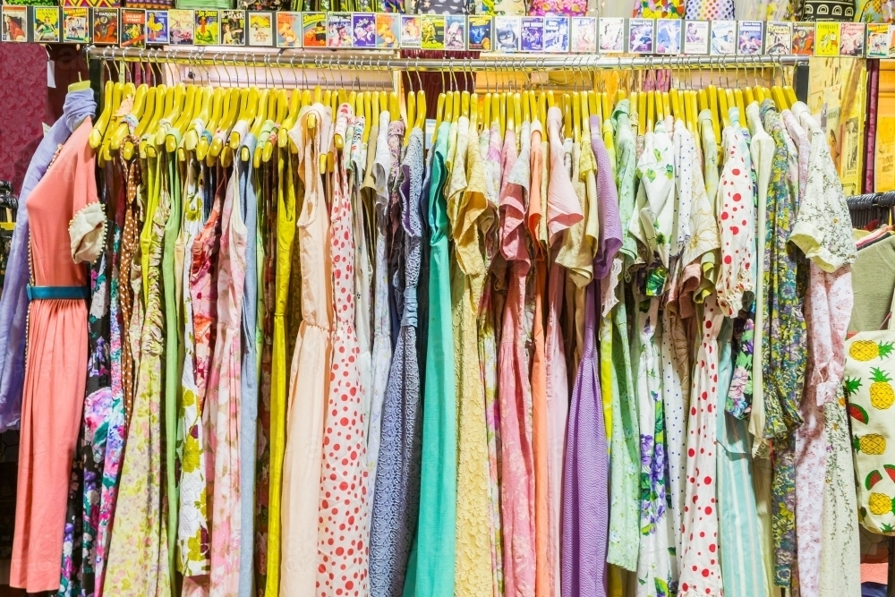 Image of A rack full of colourful vintage dresses - Austockphoto