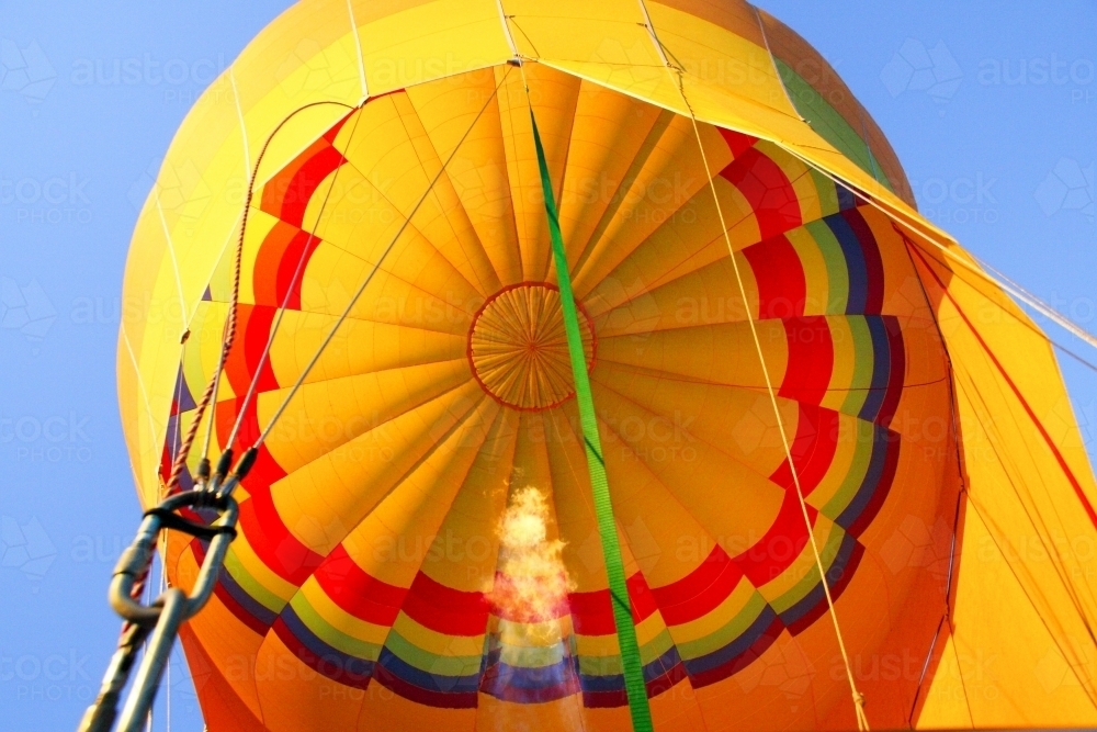 Image of A rainbow colored hot air balloon inflating in front of a ...