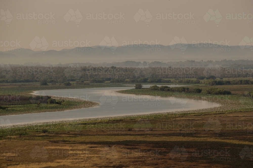 Image of A river winding through a flat terrain. - Austockphoto