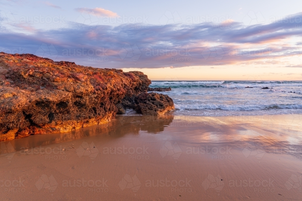 Image of A rocky coastline coloured red by afternoon light with evening ...