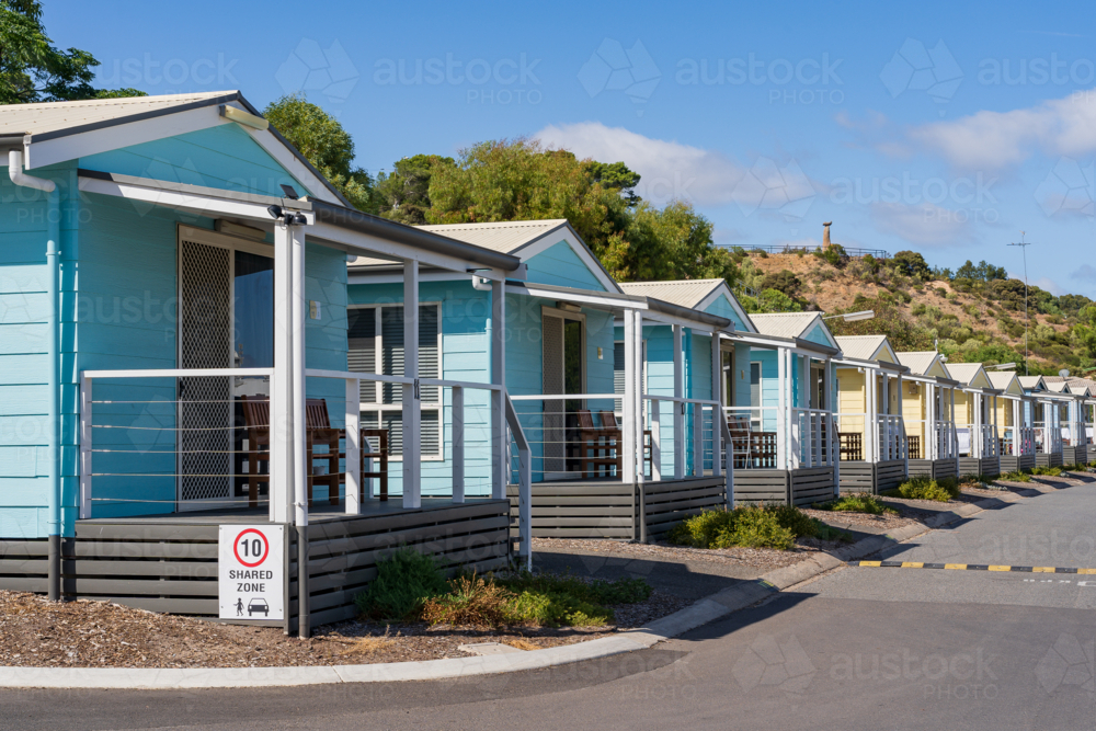 Image of A row of colourful tourist cabins in a caravan park - Austockphoto