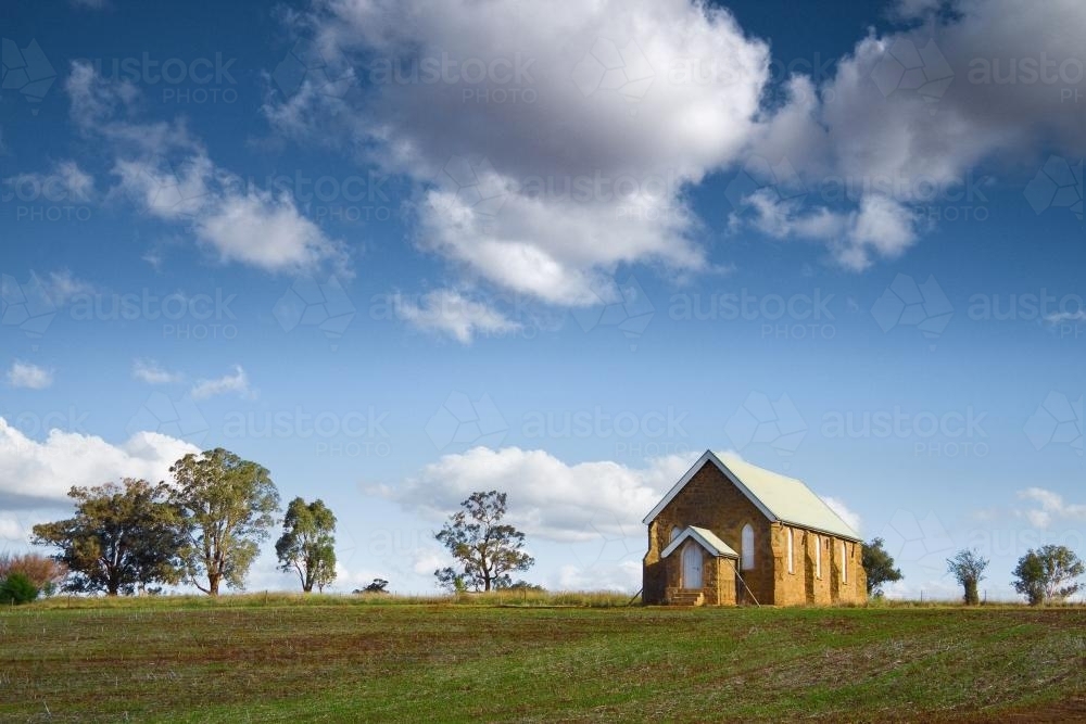 Image of A small country church under a cloudy sky - Austockphoto