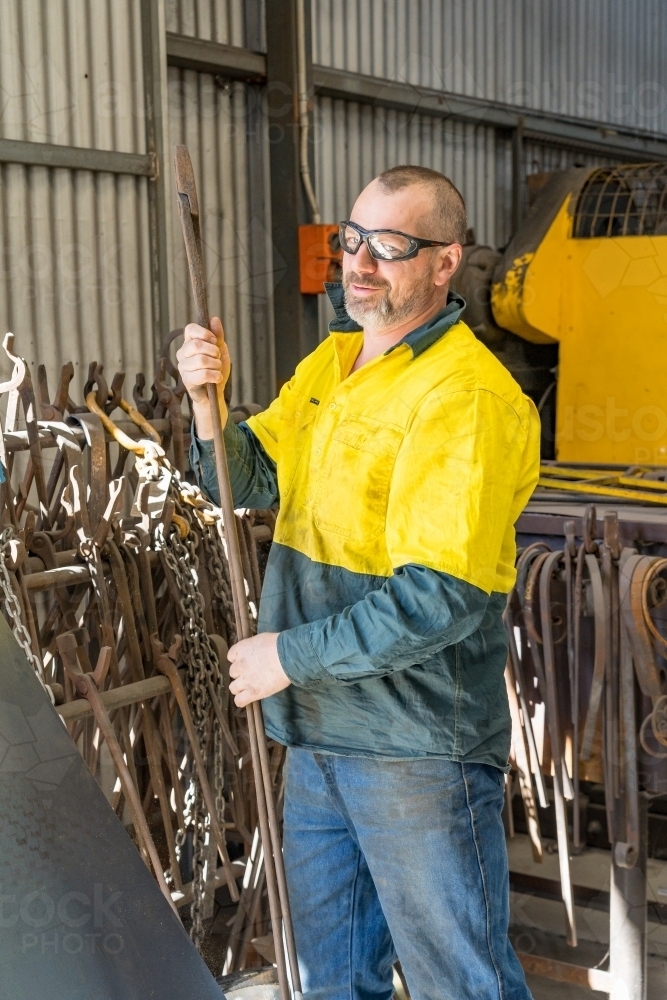 Image of A smiling tradesman wearing high vis clothing lifting a pair ...