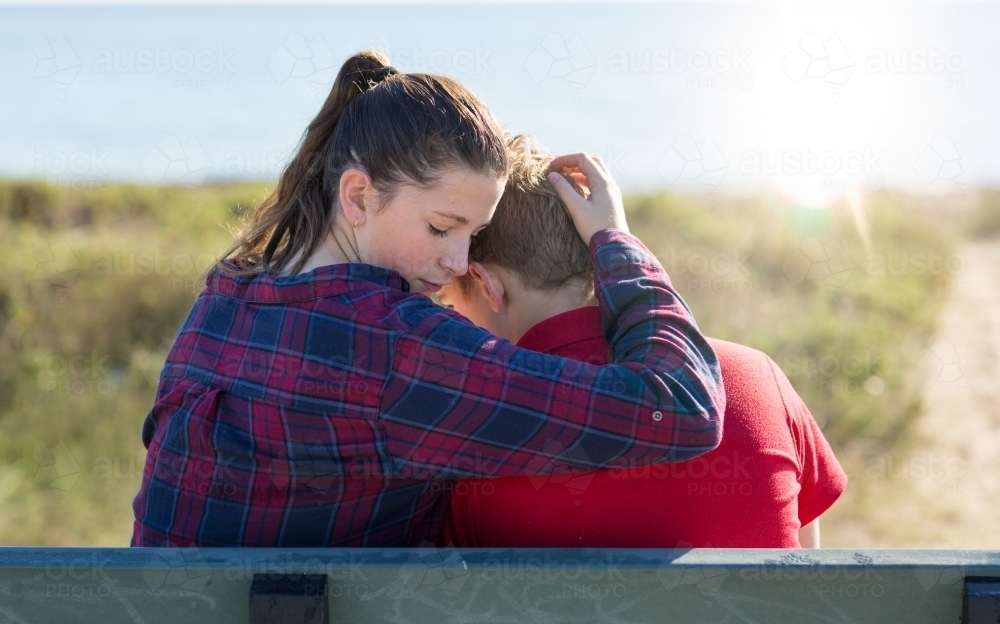 Image of A teenage girl comforting her friend - Austockphoto