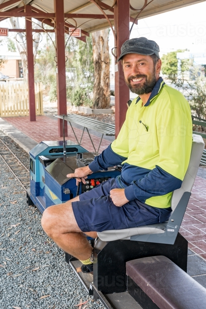 Image of A train driver sitting aboard the controls of a miniature ...