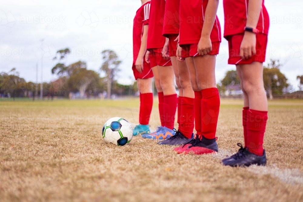 Image of A tween girls football team training together at a sports oval ...