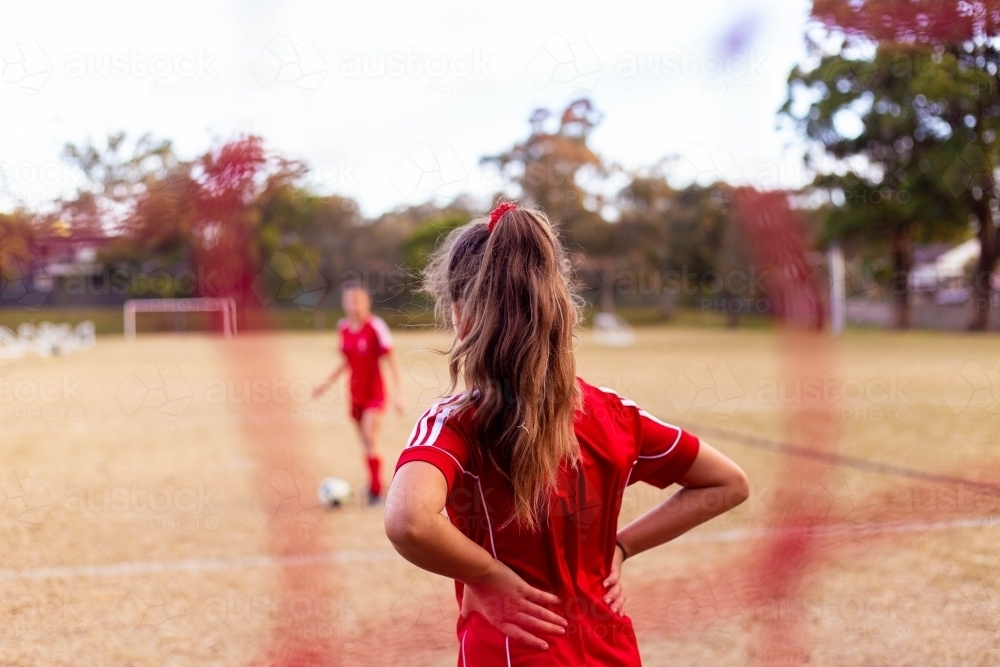 Image of A tween girls football team training together at a sports oval ...
