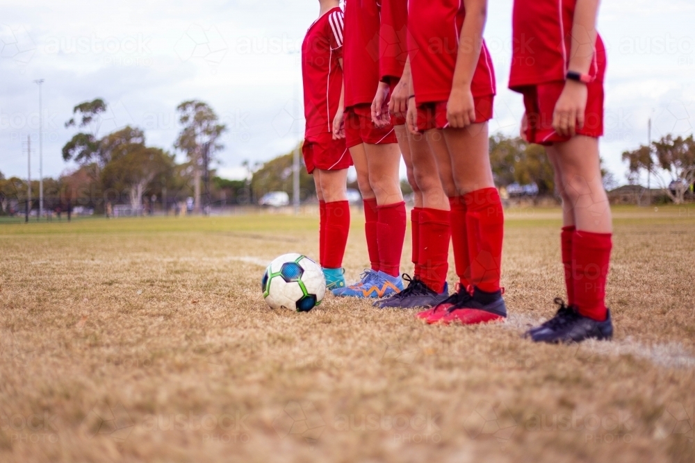 Image of A tween girls football team training together at a sports oval ...