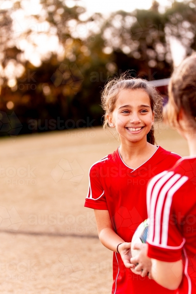 Image of A tween girls football team training together at a sports oval ...