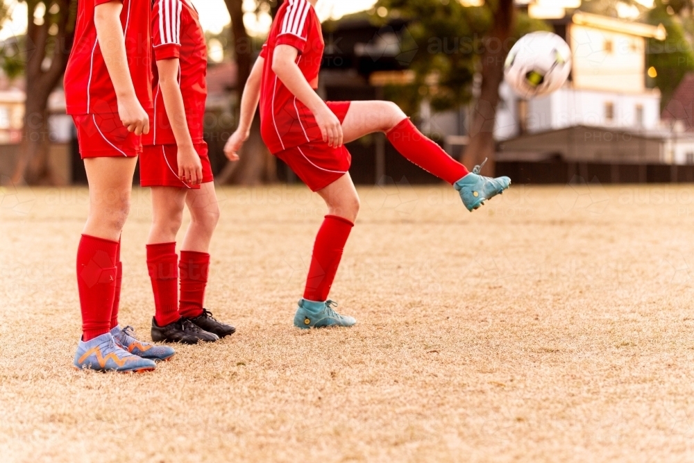 Image of A tween girls football team training together at a sports oval ...
