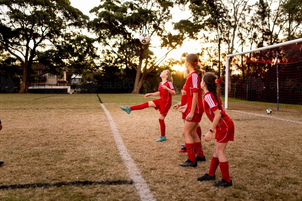Image of A tween girls football team training together at a sports oval ...