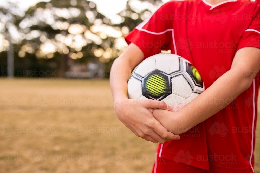 Image of A tween girls football team training together at a sports oval ...