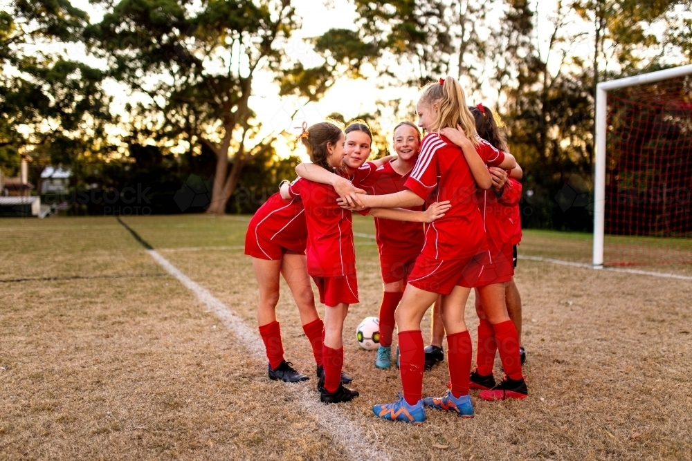 Image of A tween girls football team training together at a sports oval ...