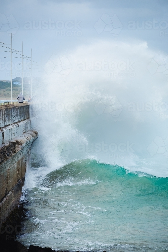 Image of A wild wave crashes against the breakwall - Austockphoto