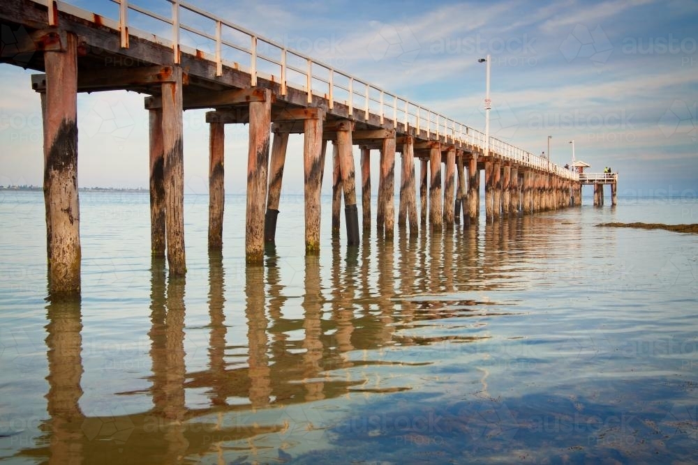 Image of A wooden jetty leading out to sea - Austockphoto