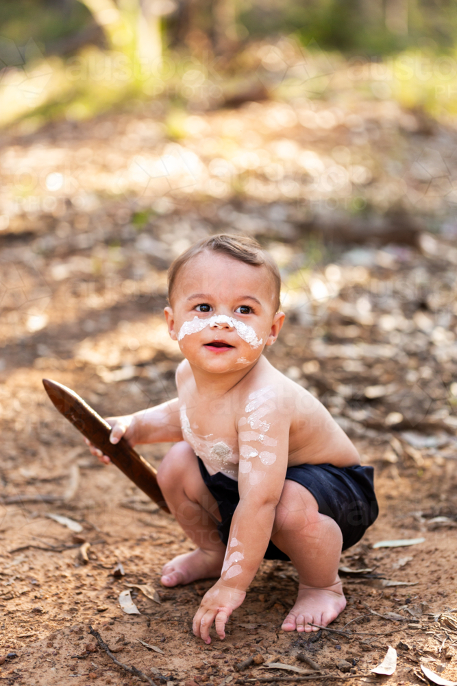 Image of Aboriginal Australian child exploring bushland holding ...