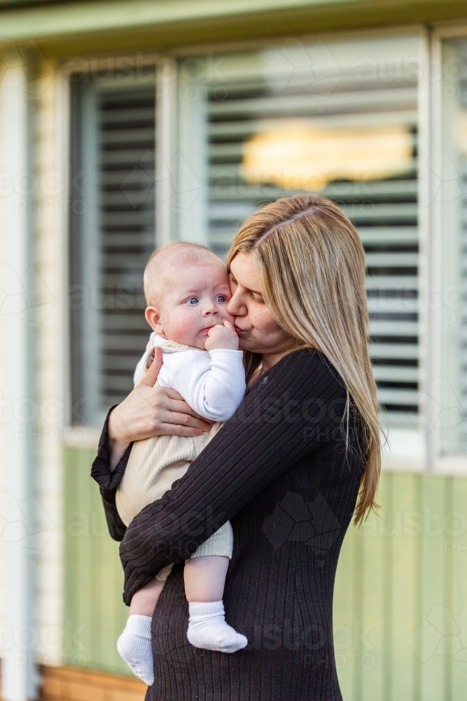 Image of Aboriginal australian mum kissing baby boy on cheek outside ...