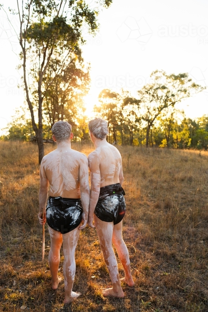 Image of Aboriginal australian young men on country at sunset in ochre ...