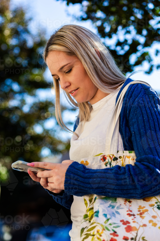 Image of Aboriginal Australian young woman in country town using phone ...