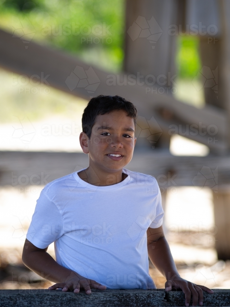 Image of Aboriginal Boy, with pier in background - Austockphoto