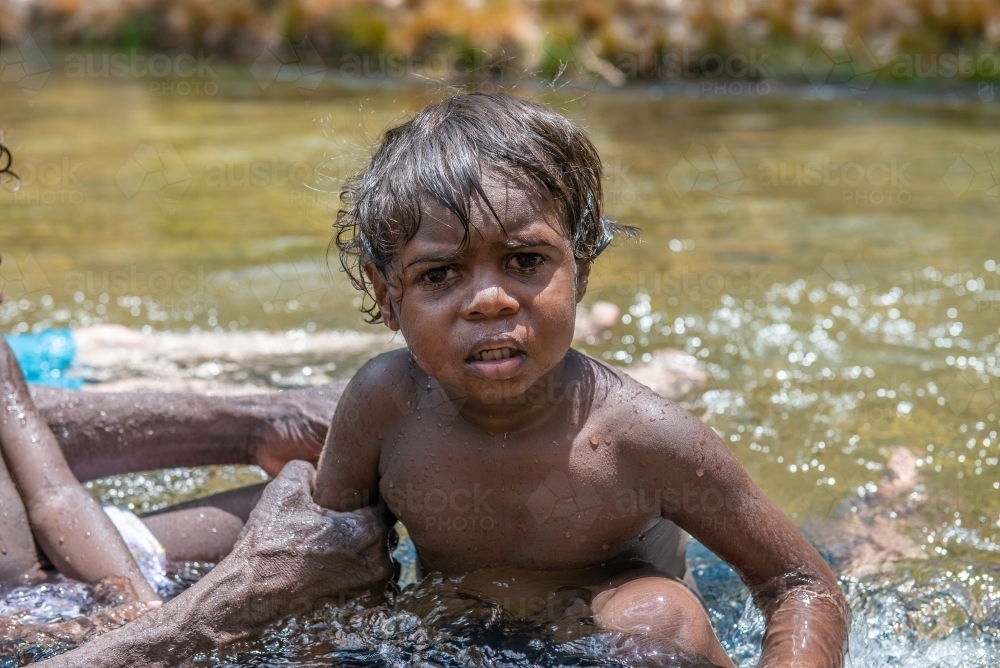 Image of Aboriginal boy in a river - Austockphoto