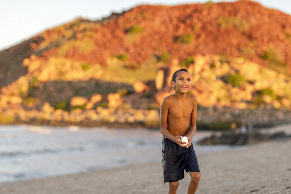 Image of aboriginal boy on the beach after sundown with Pilbara ...