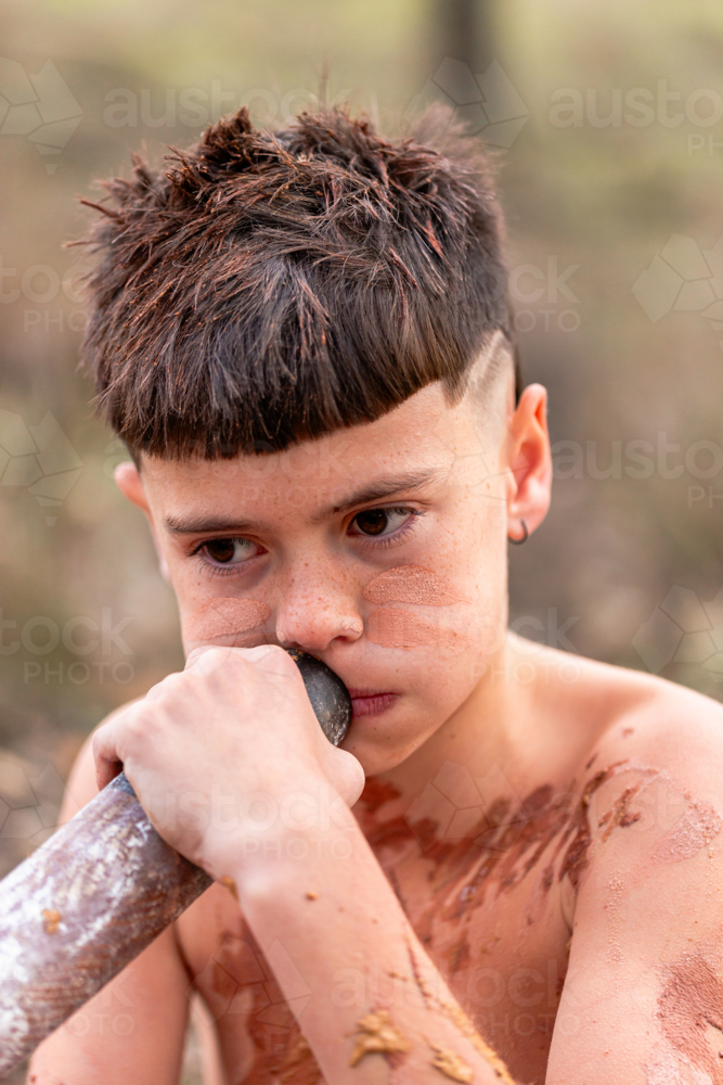 Image of aboriginal child playing didgeridoo wearing traditional ochre ...