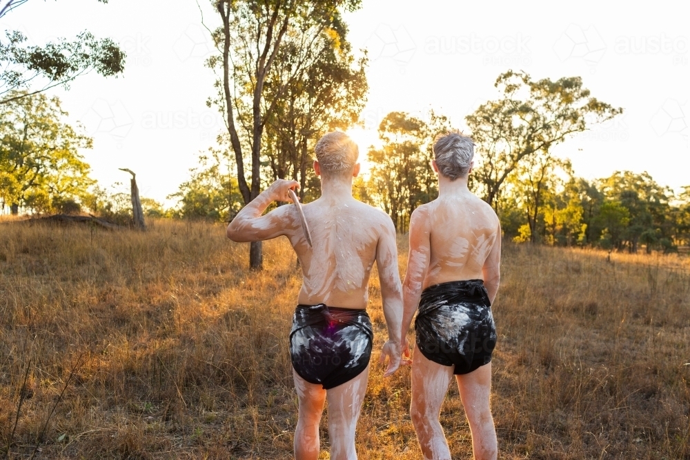 Image of Aboriginal cousins standing together looking towards sunset ...