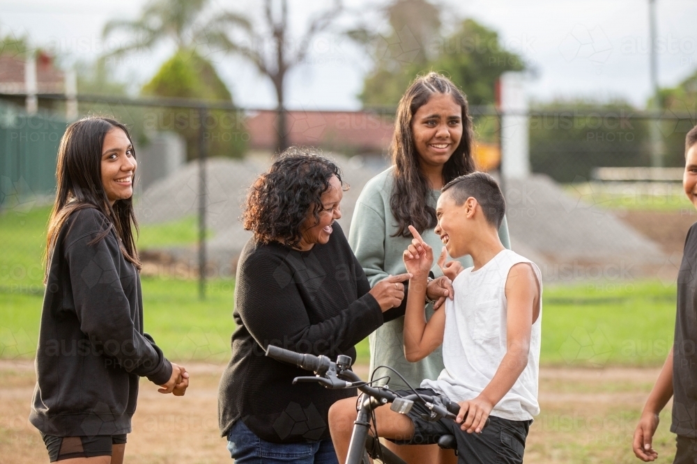 Image of Aboriginal family laguhing and talking outside - Austockphoto