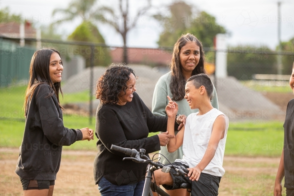 Image of Aboriginal family laguhing and talking outside - Austockphoto