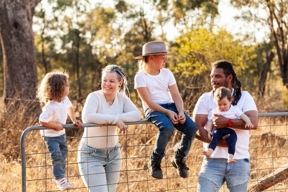Image of Aboriginal family portrait on farm paddock gate with parents ...
