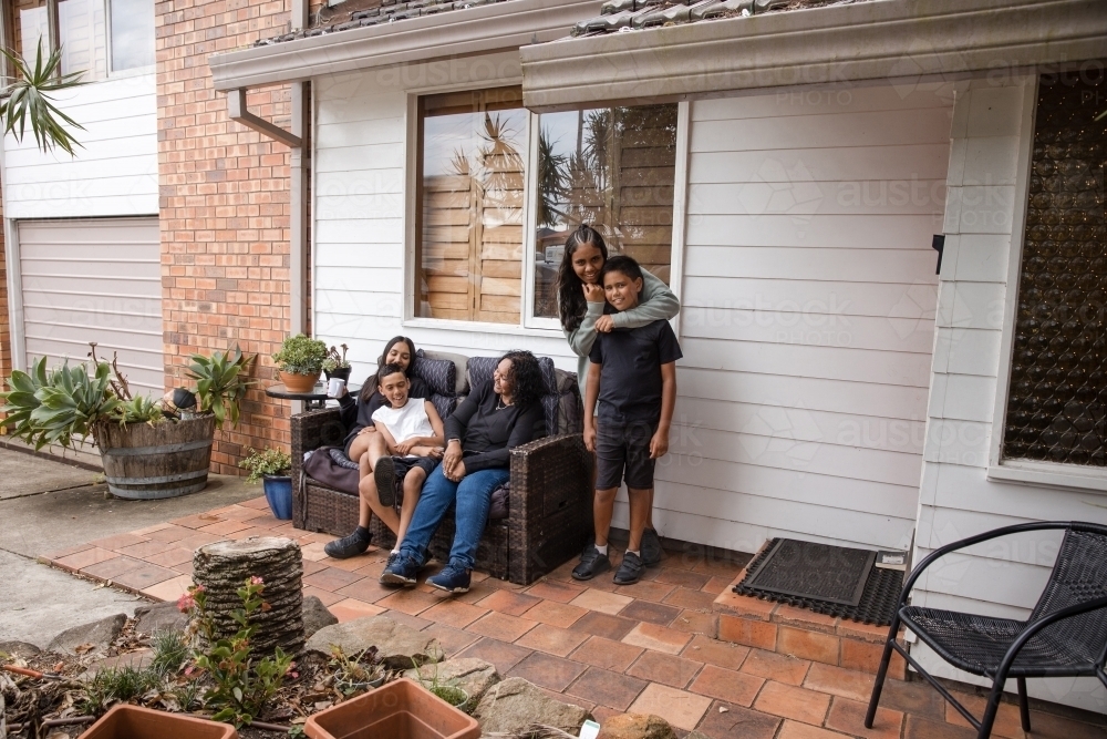 Image of Aboriginal family sitting on outside chair - Austockphoto
