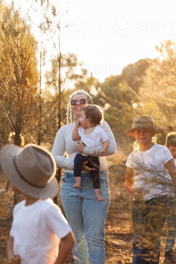 Image of Aboriginal family walking together through bushland - Austockphoto