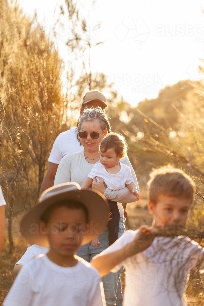 Image of Aboriginal family walking together through bushland - Austockphoto