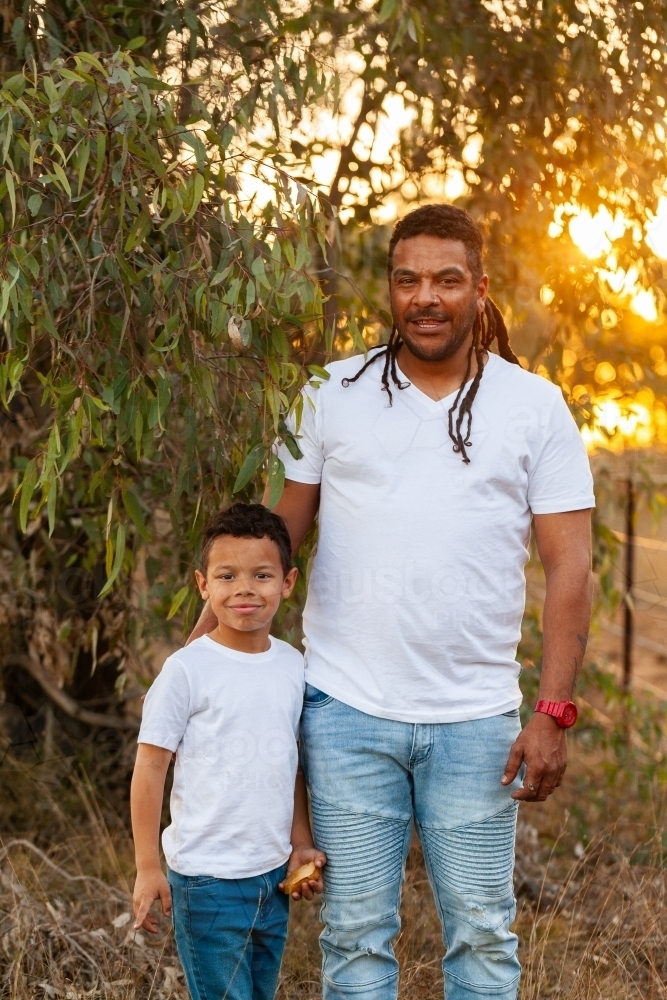Image of Aboriginal father and son portrait with leafy background in ...