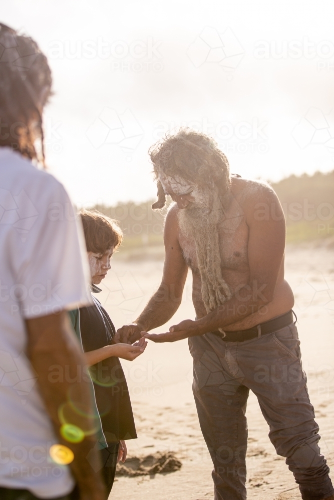 Image of Aboriginal father helping young Aboriginal son on beach ...