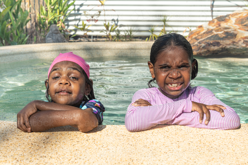 Image of Aboriginal girls leaning on pool edge - Austockphoto