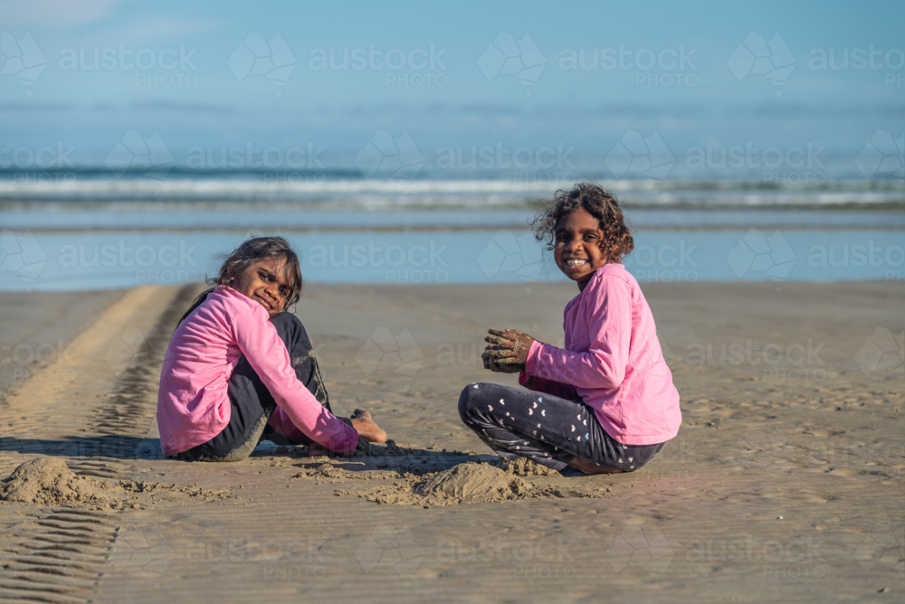 Image of Aboriginal girls playing in sand - Austockphoto