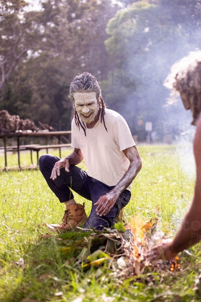 Image of Aboriginal man helping prepare a smoke ceremony - Austockphoto
