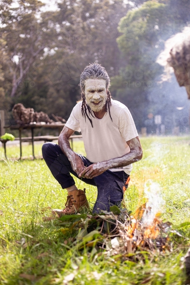 Image of Aboriginal man helping prepare a smoke ceremony - Austockphoto