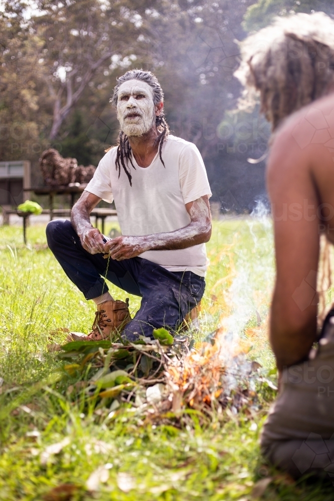 Image of Aboriginal man helping prepare a smoke ceremony - Austockphoto