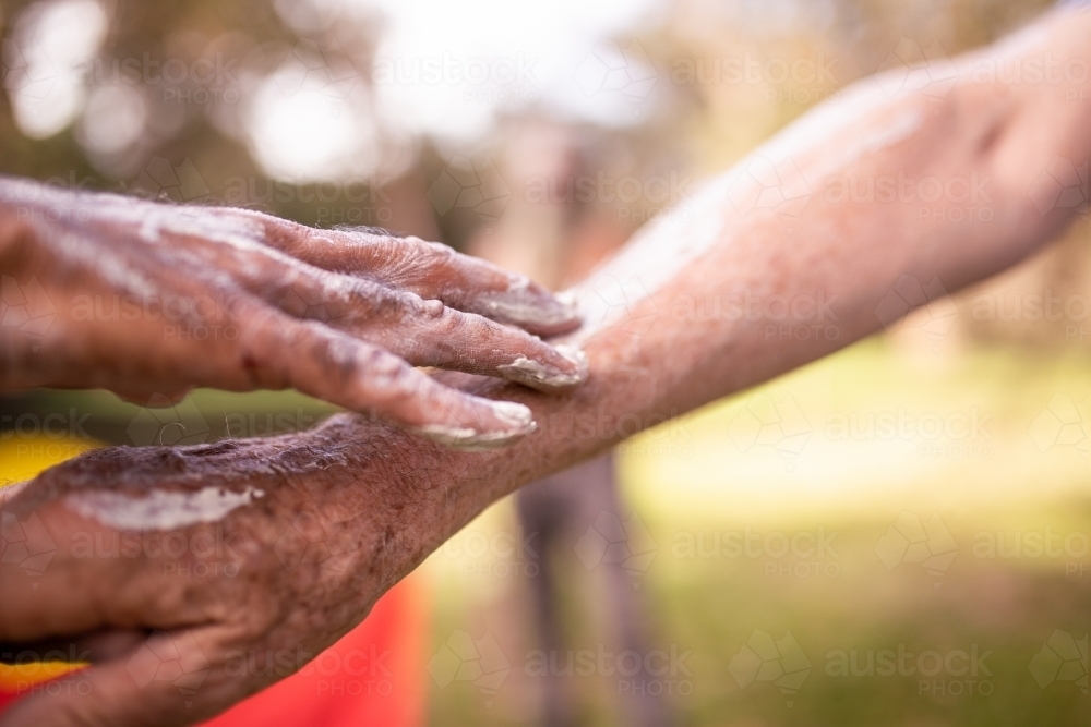Image of Aboriginal man putting traditional white paint on a Caucasian ...