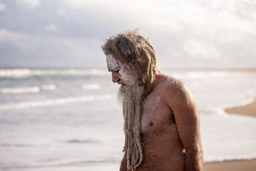 Image of Aboriginal middle aged man with clay face paint standing on a ...