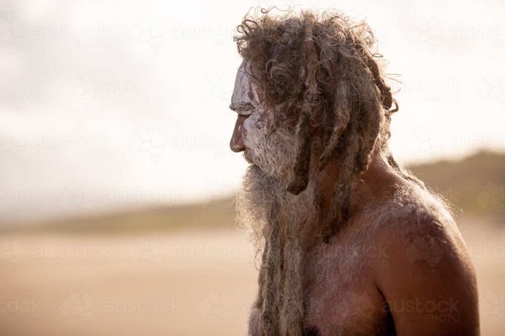 Image of Aboriginal middle aged man with clay face paint standing on a ...