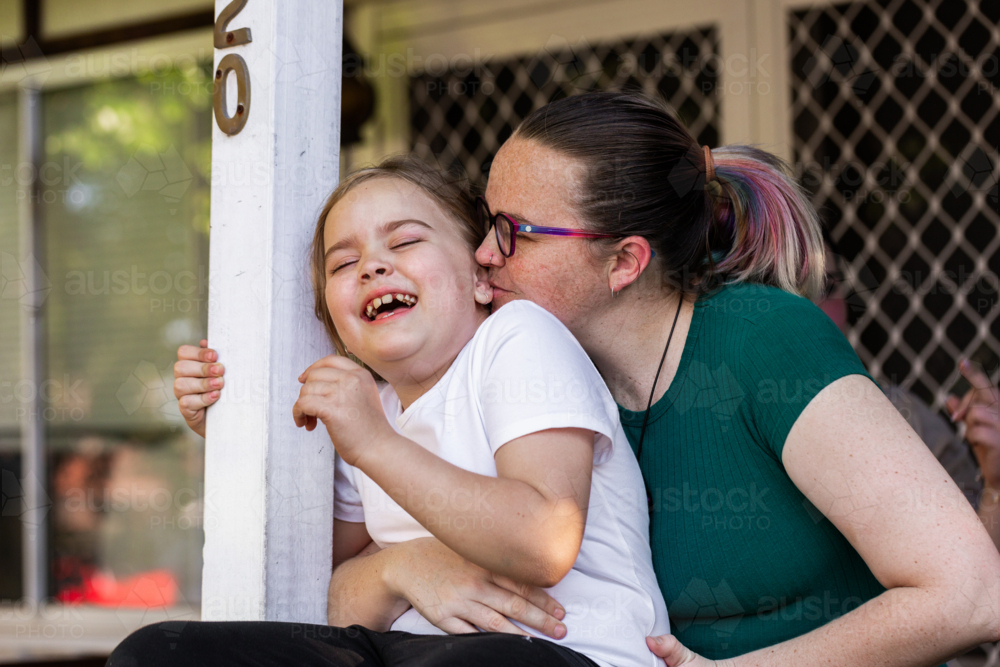 Image of Aboriginal mother in her thirties playing with young daughter ...