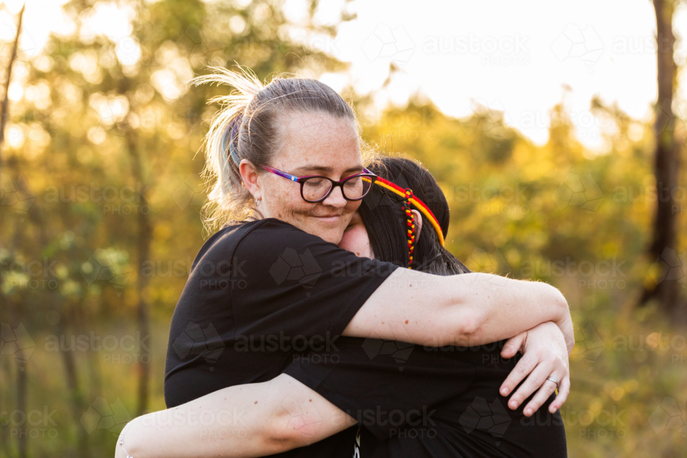 Image of Aboriginal mum and daughter hugging in golden light in ...
