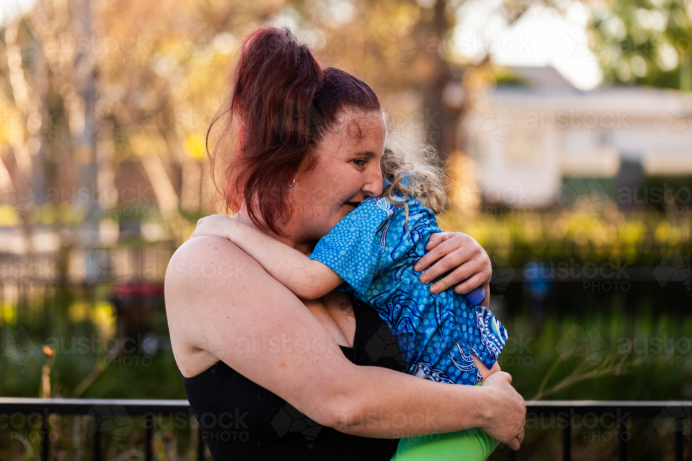 Image of Aboriginal mum hugging daughter outside home comforting her ...