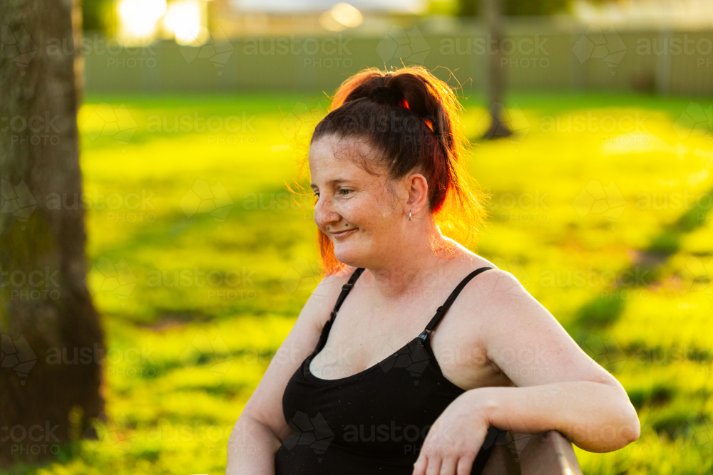 Image of Aboriginal mum sitting on park bench watching children ...