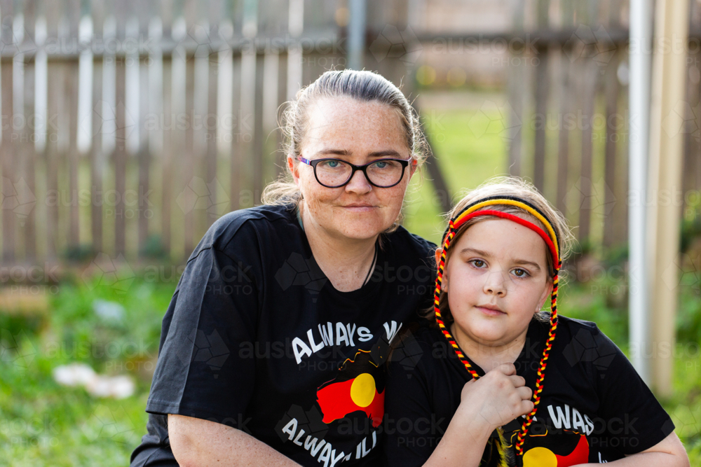 Image of Aboriginal mum sitting with daughter in Aussie backyard ...