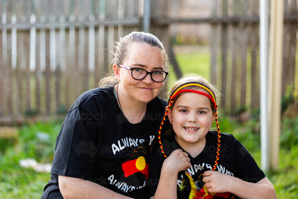 Image of Aboriginal mum sitting with daughter in Aussie backyard ...